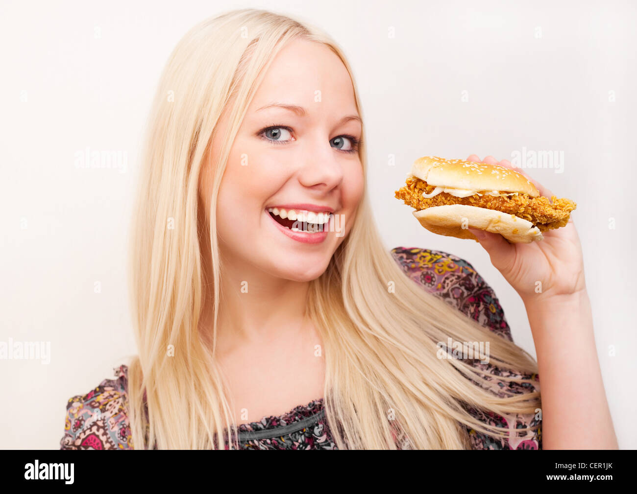 beautiful woman eating a burger, isolated against white background ...
