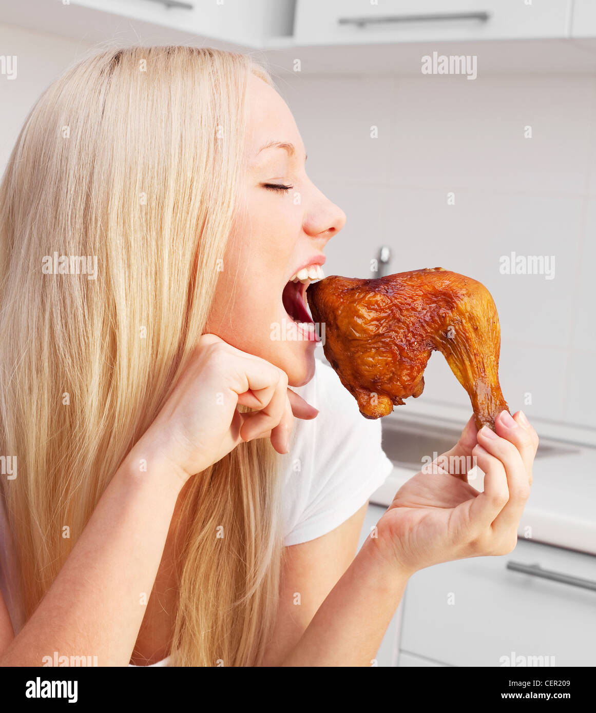 Beautiful young woman eating chicken hi-res stock photography and ...