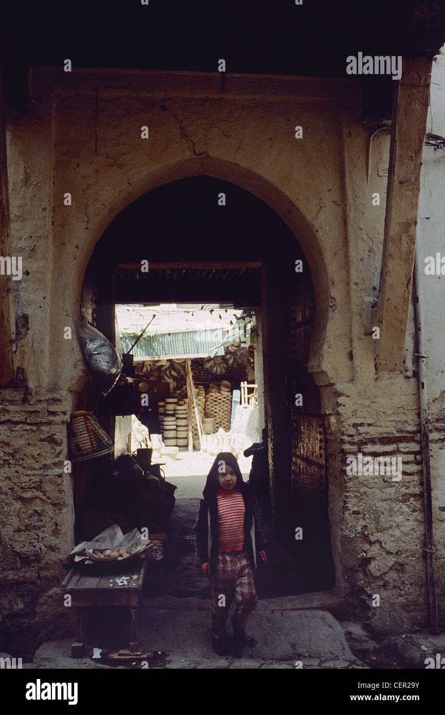 A boy walks through an archway in the old city of Fez, Morocco Stock ...