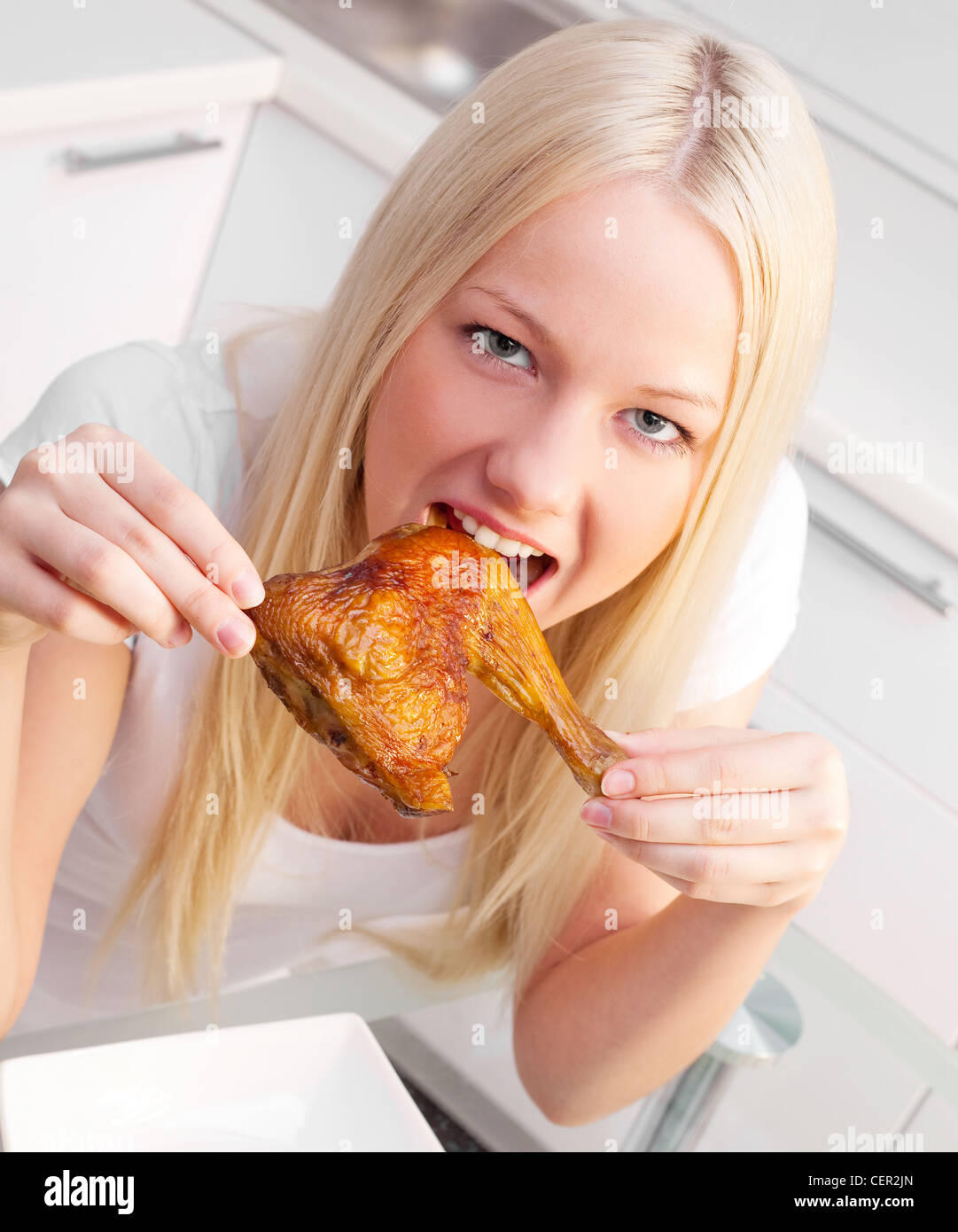 beautiful young woman eating chicken at home Stock Photo - Alamy