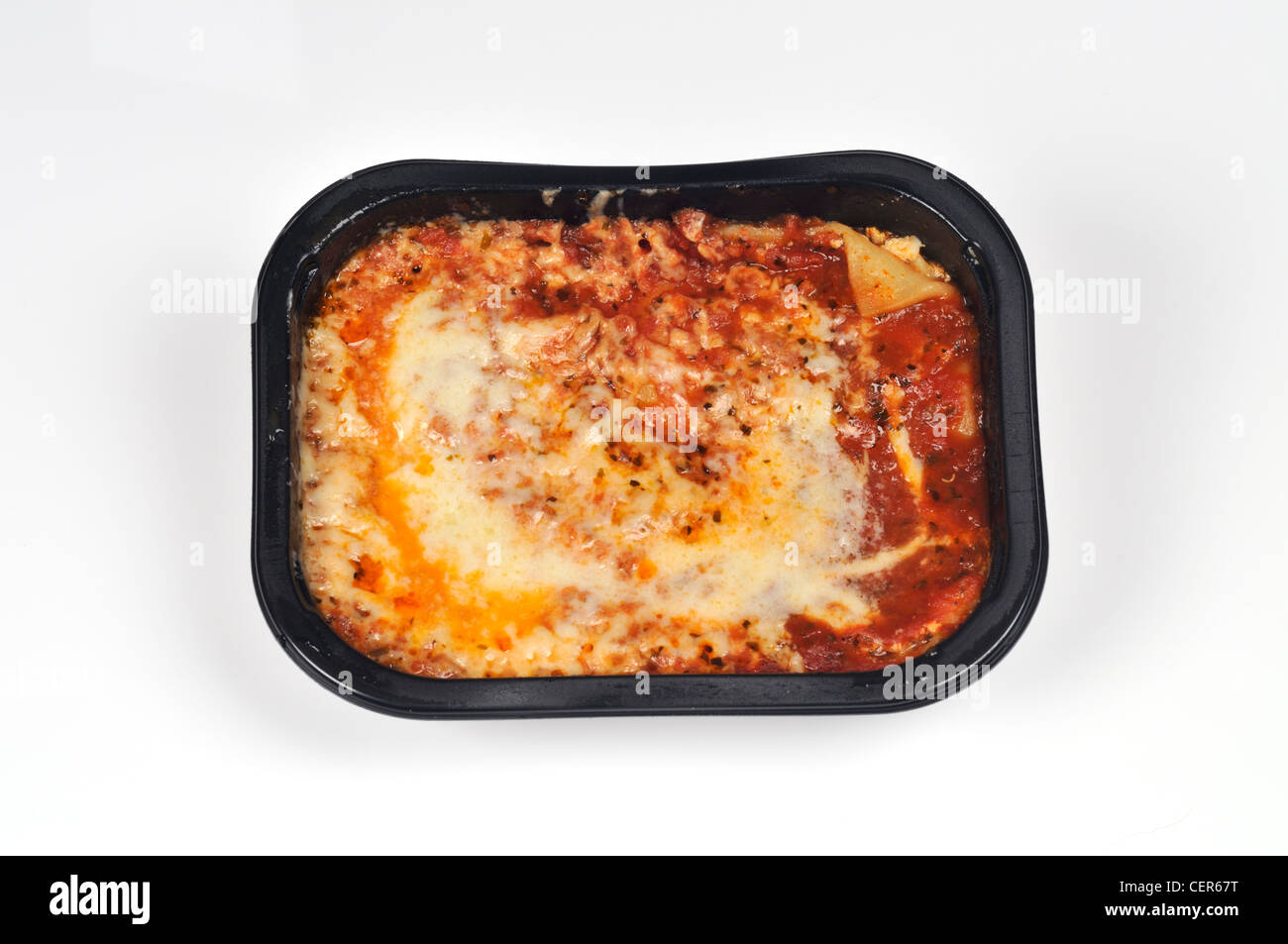 Cooked cheese lasagna ready meal in black plastic tray on white ...