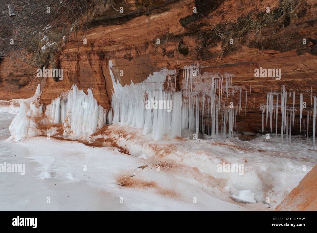 A man exploring an ice cave on the shore of Lake Superior near ...