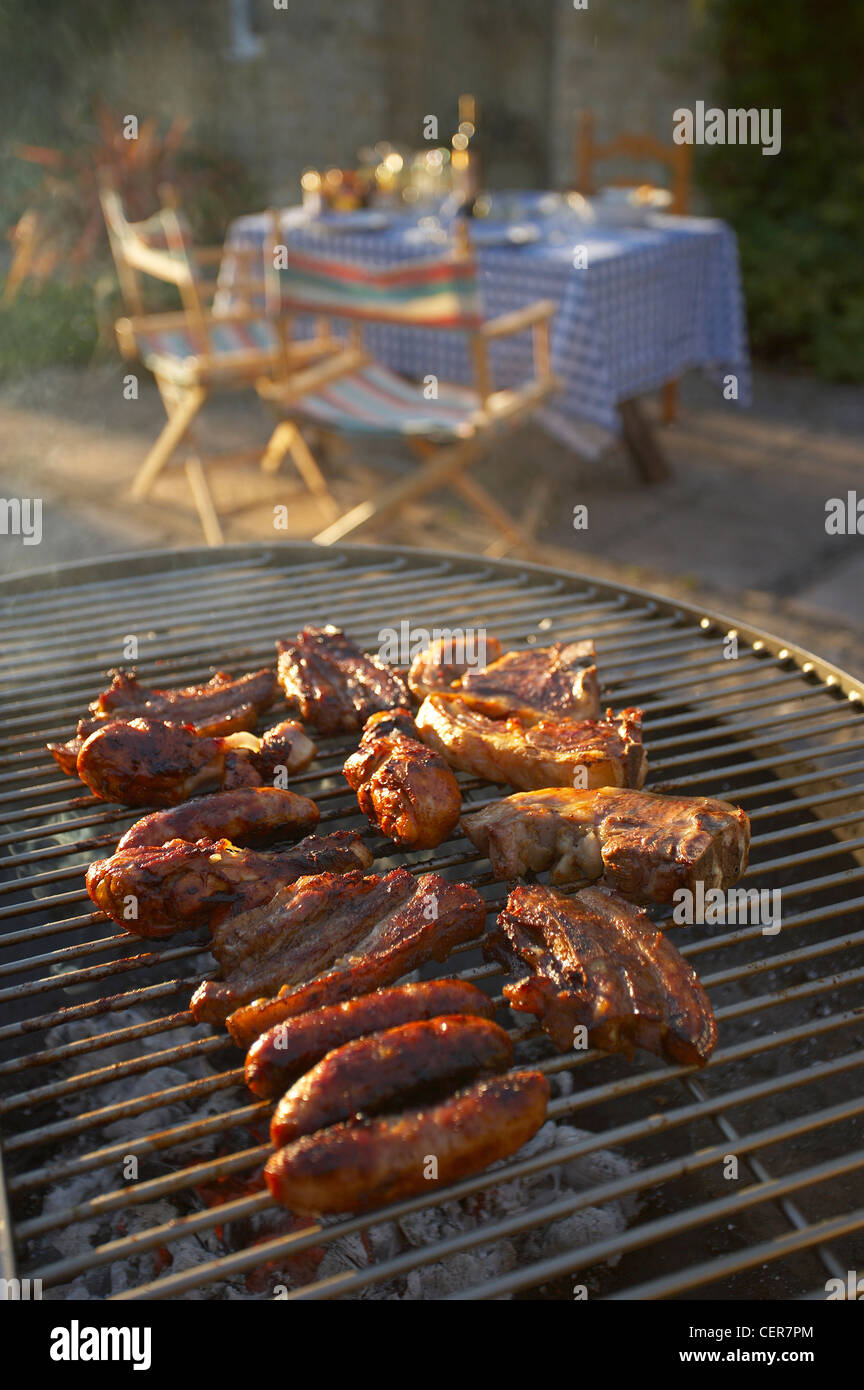 meat grilling on a charcoal barbeque in a Dorset garden on a summer ...