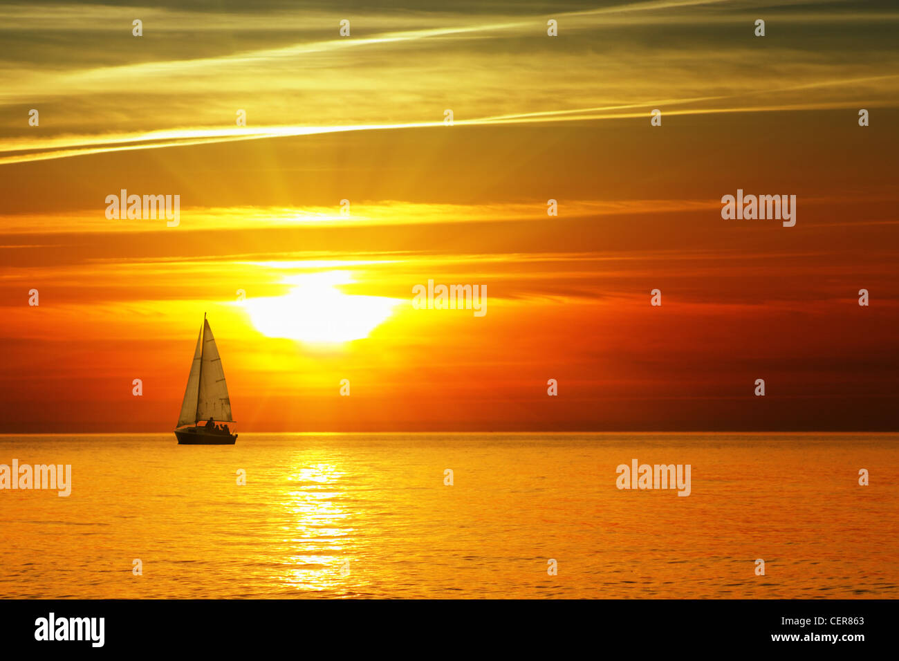 Sailboat on the ocean at sunset Stock Photo - Alamy