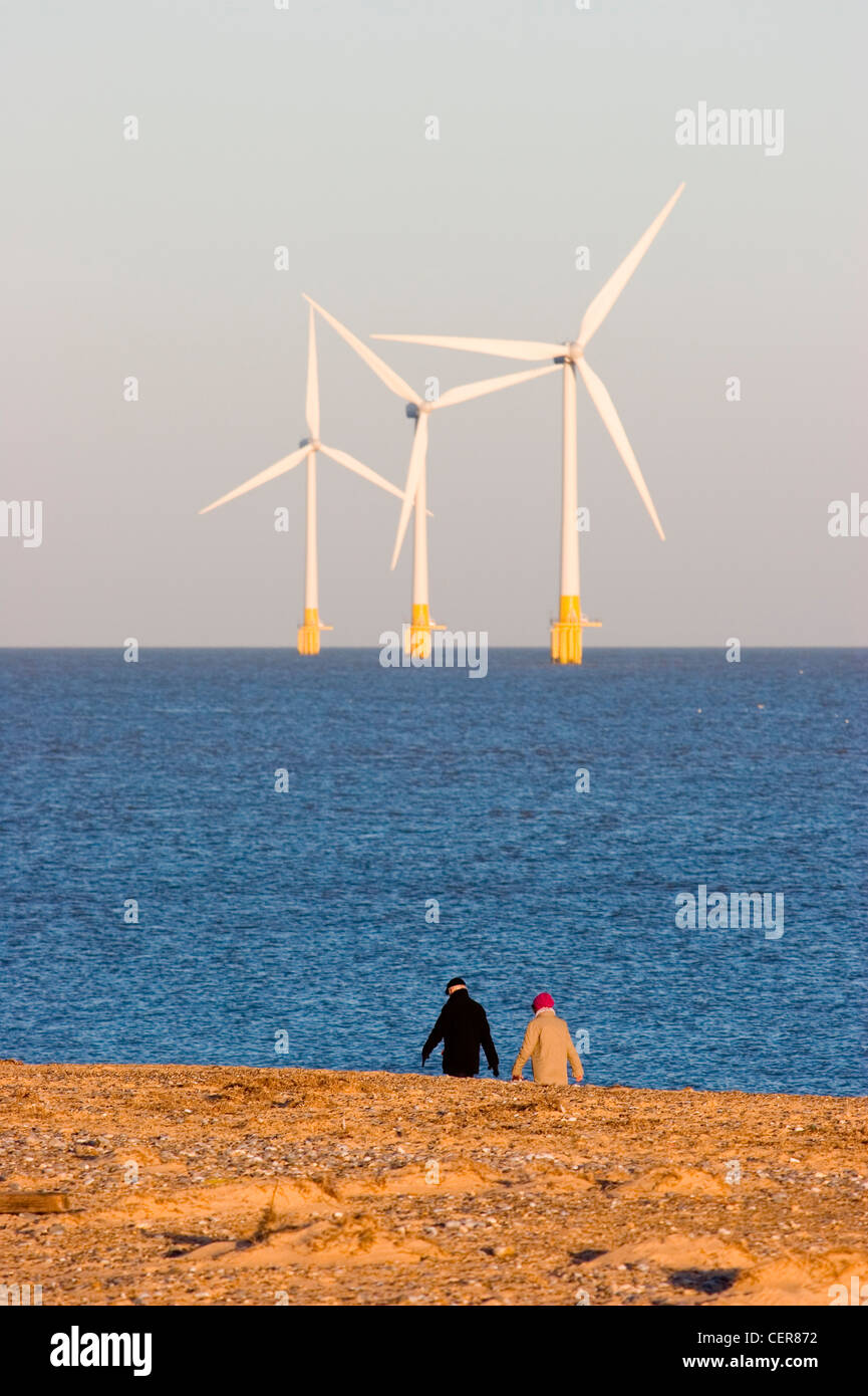 Offshore wind farm with couple walking along the foreshore in Great ...