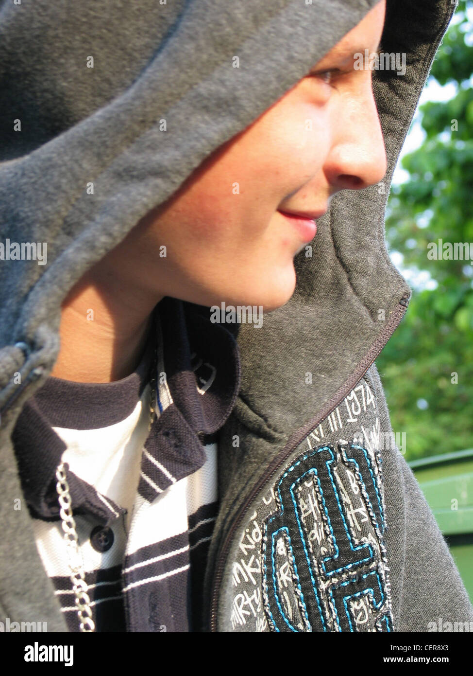 Close up profile of teenage male wearing grey hooded top smiling Stock ...