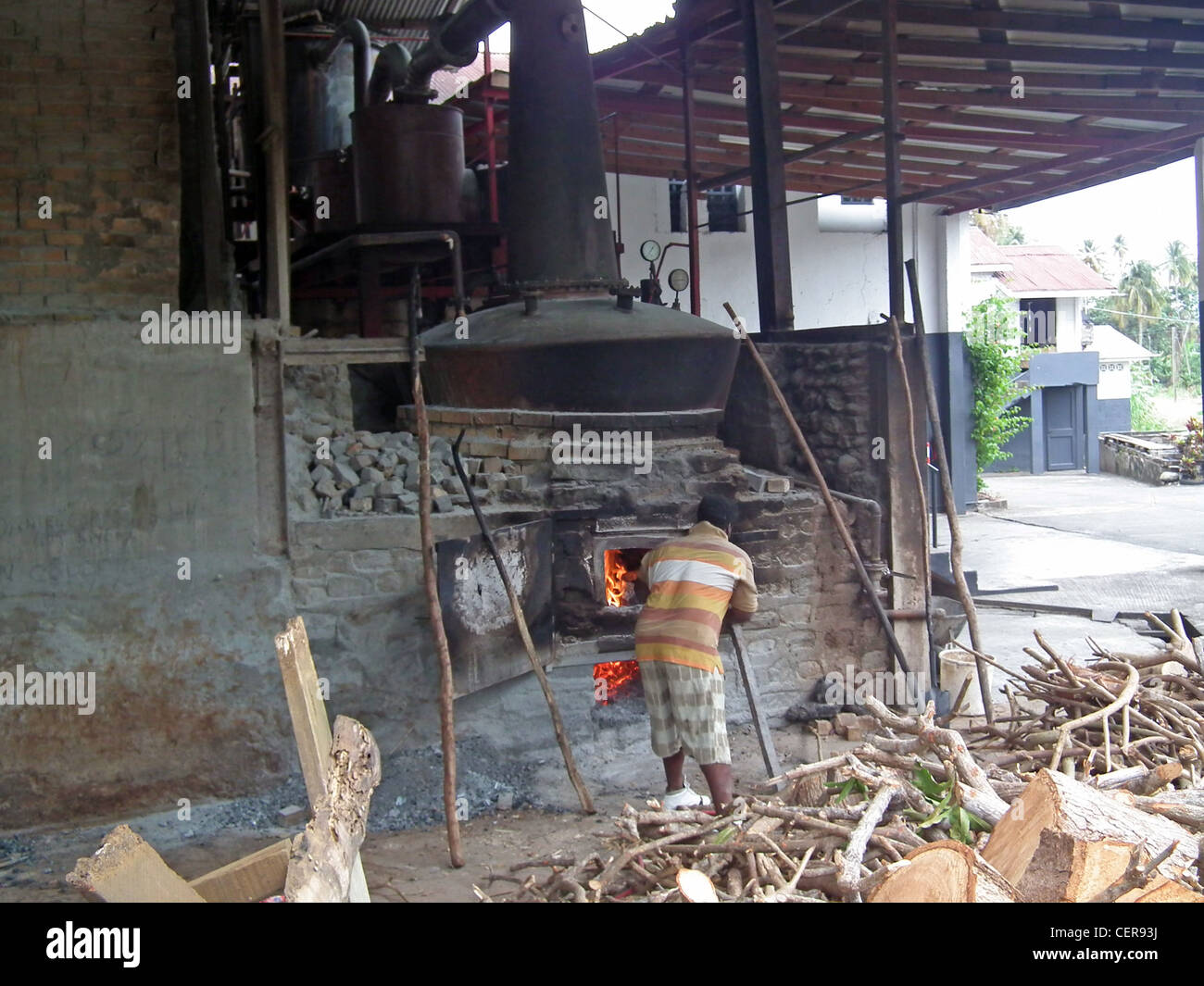 GRENADA Rum factory - putting wood into the furnance to distill the ...