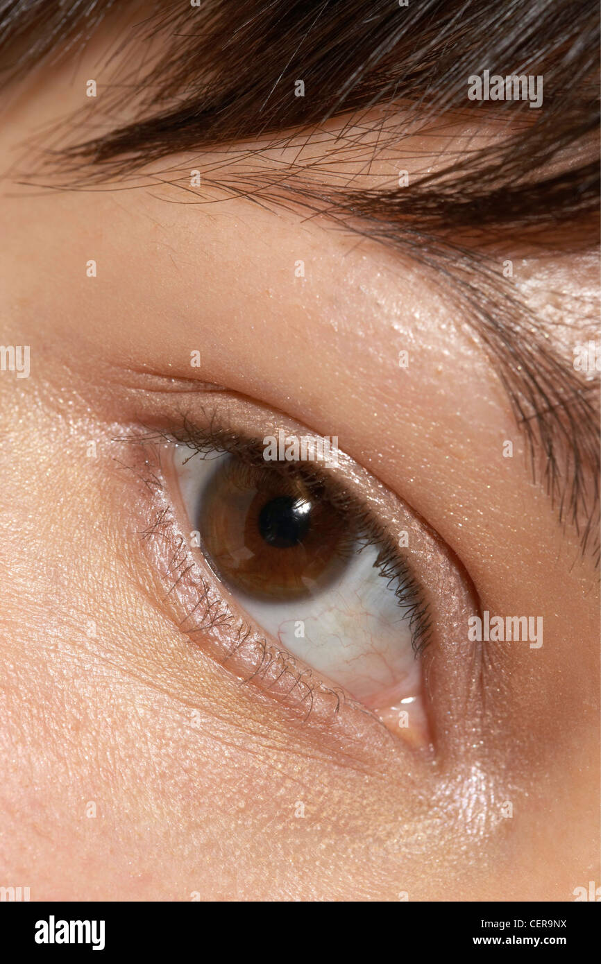 Close up eye of female wearing metallic eyeshadow, looking straight to ...