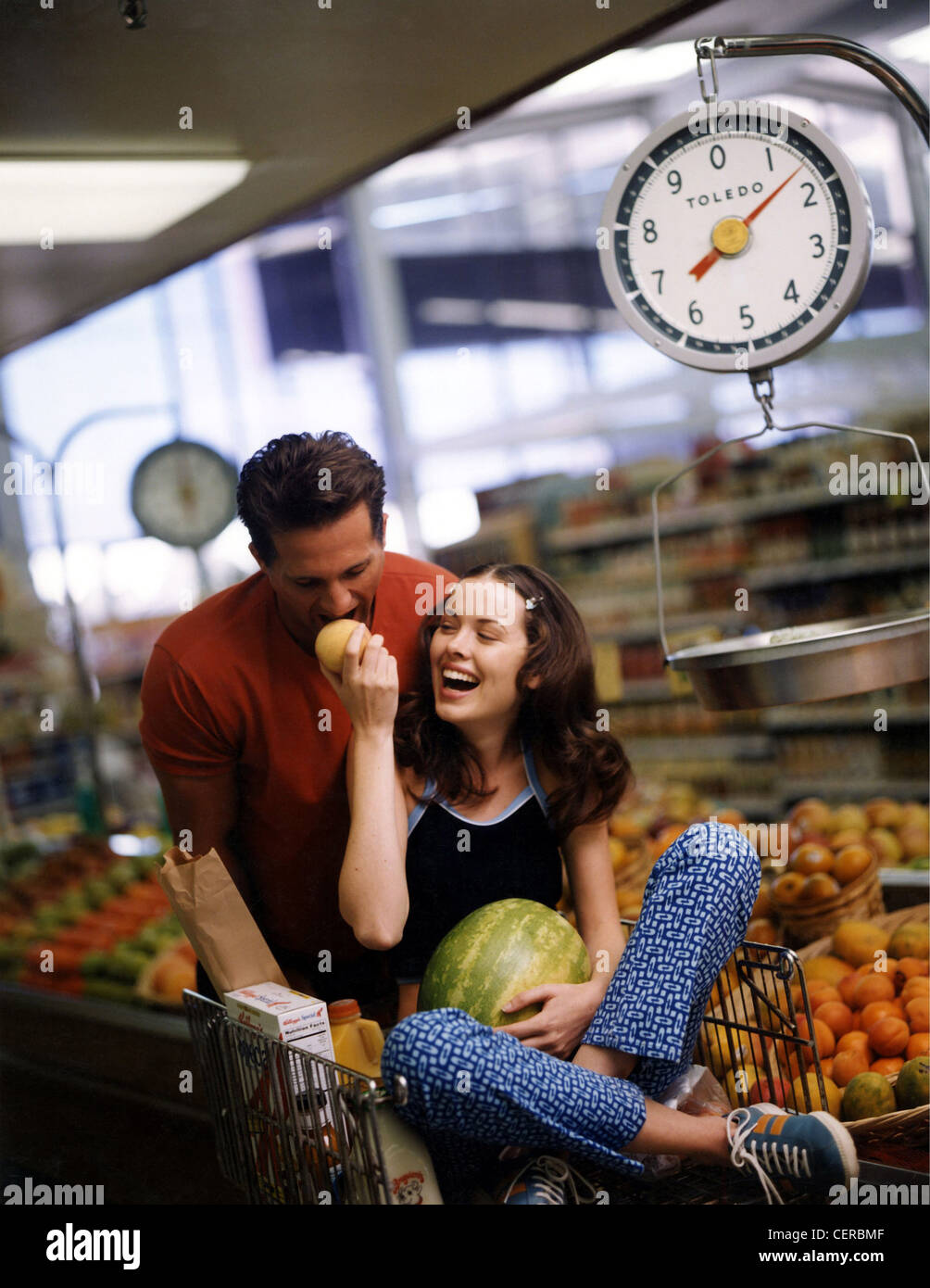 Brunette couple having fun shopping in the grocery store Female is ...