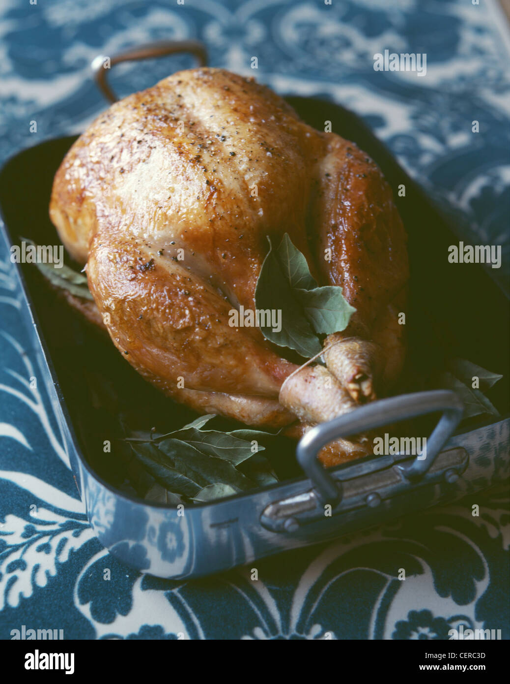 A roasted turkey on a bed of bay leaves in a blue roasting tray Stock ...