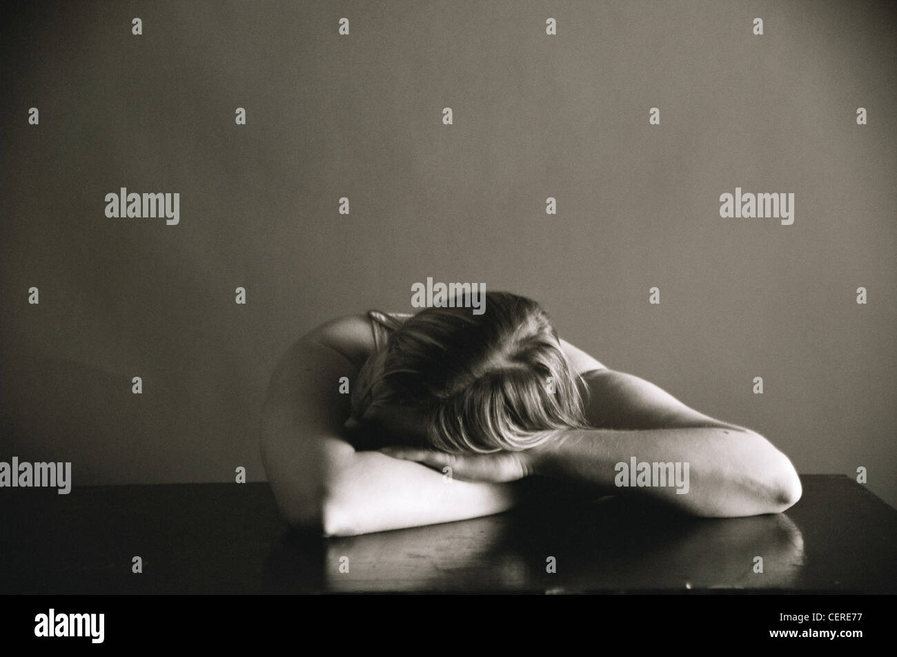 Head and shoulders of female with long blonde hair resting her head on ...