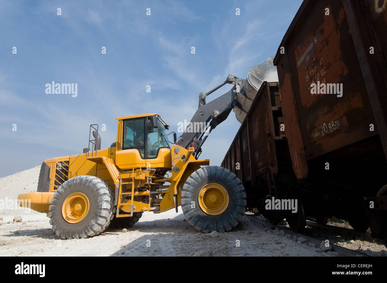 excavator loads gravel into the car of a train Stock Photo - Alamy