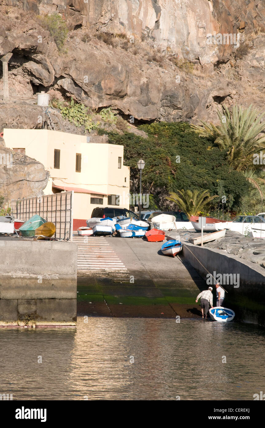 Two local men pull a small boat up the harbour slipway Stock Photo - Alamy