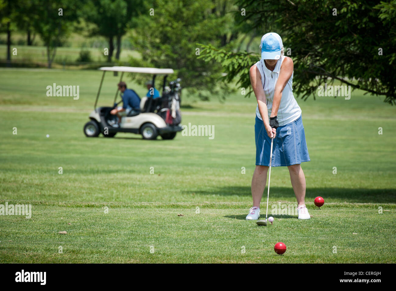 Woman driving the ball on a golf course Stock Photo - Alamy