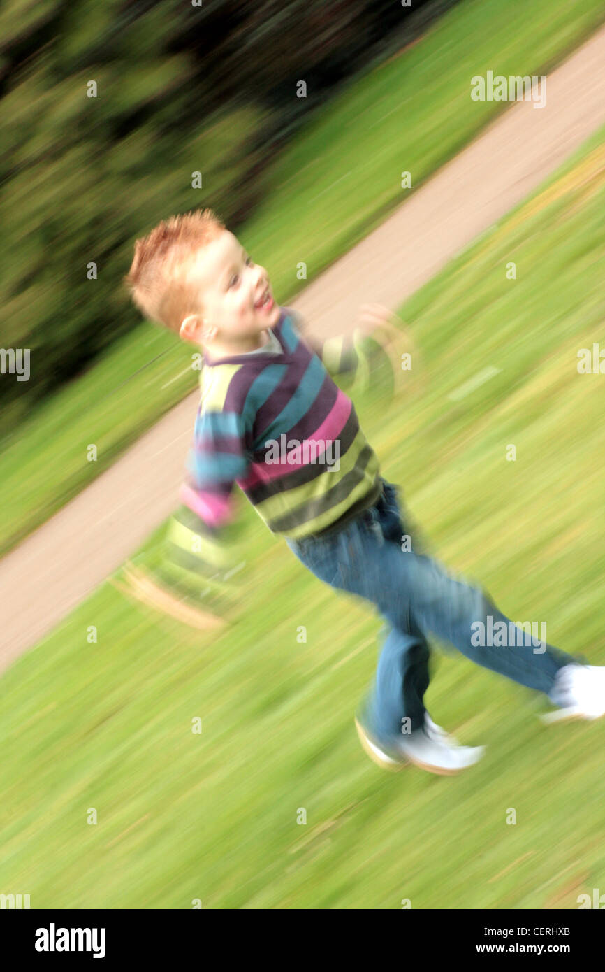 Boy running at speed through the park Stock Photo - Alamy