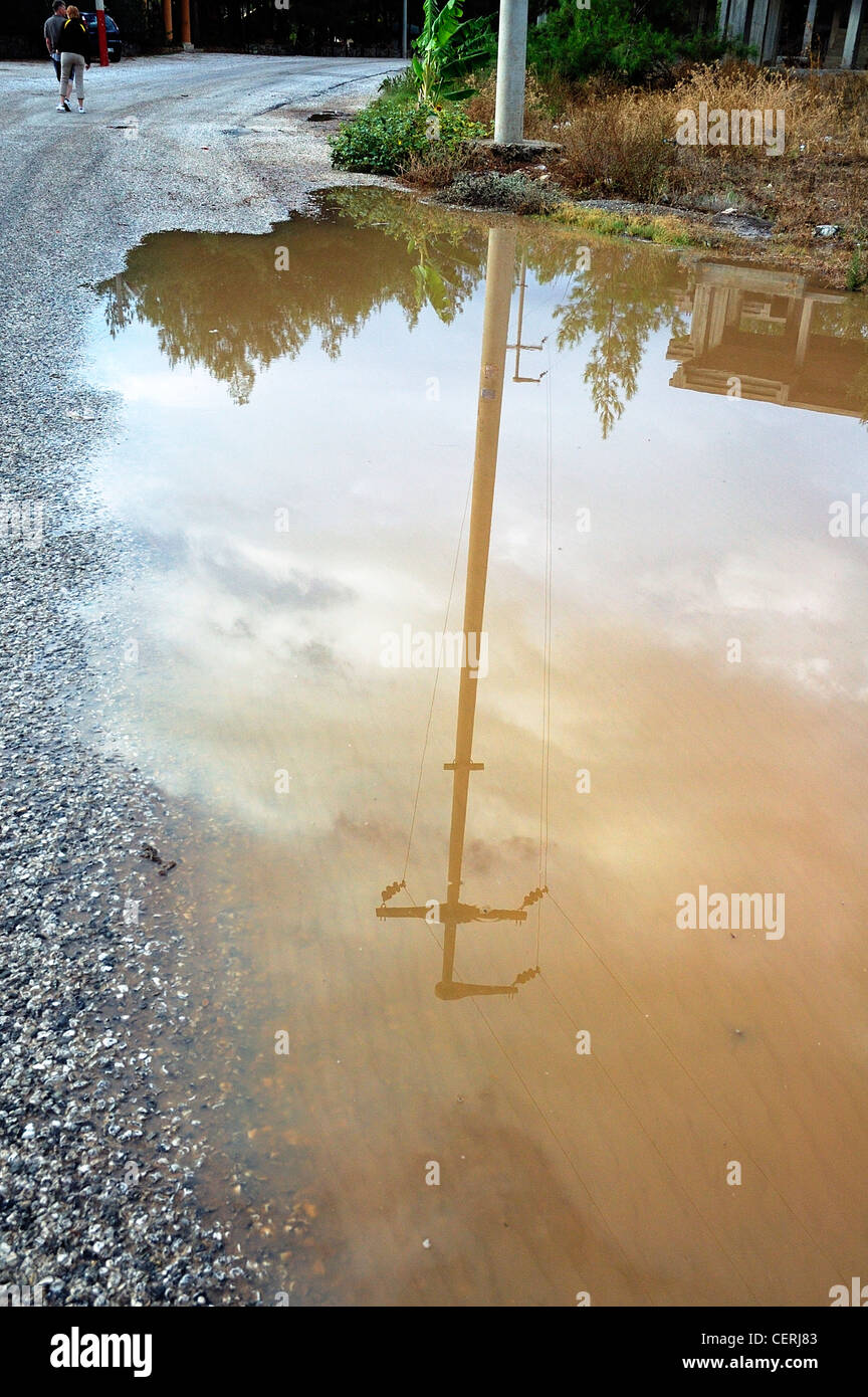 reflection of a telegraph pole in a pool of water after heavy rain ...