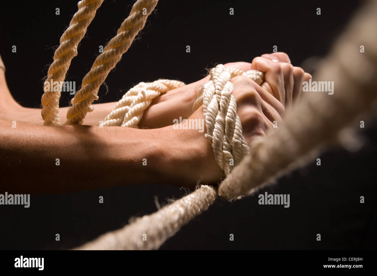 Men's hands hold tight rope Stock Photo - Alamy