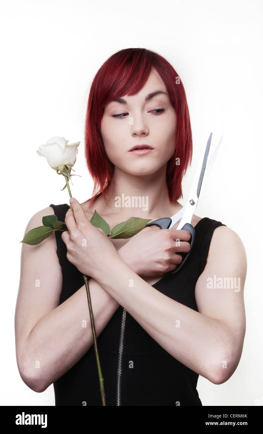 unhappy woman cutting up a single rose Stock Photo - Alamy