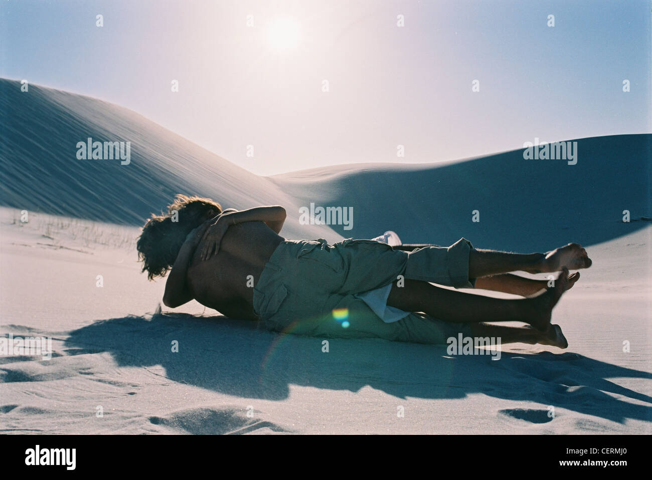 Couple rolling around on sand dune Stock Photo - Alamy