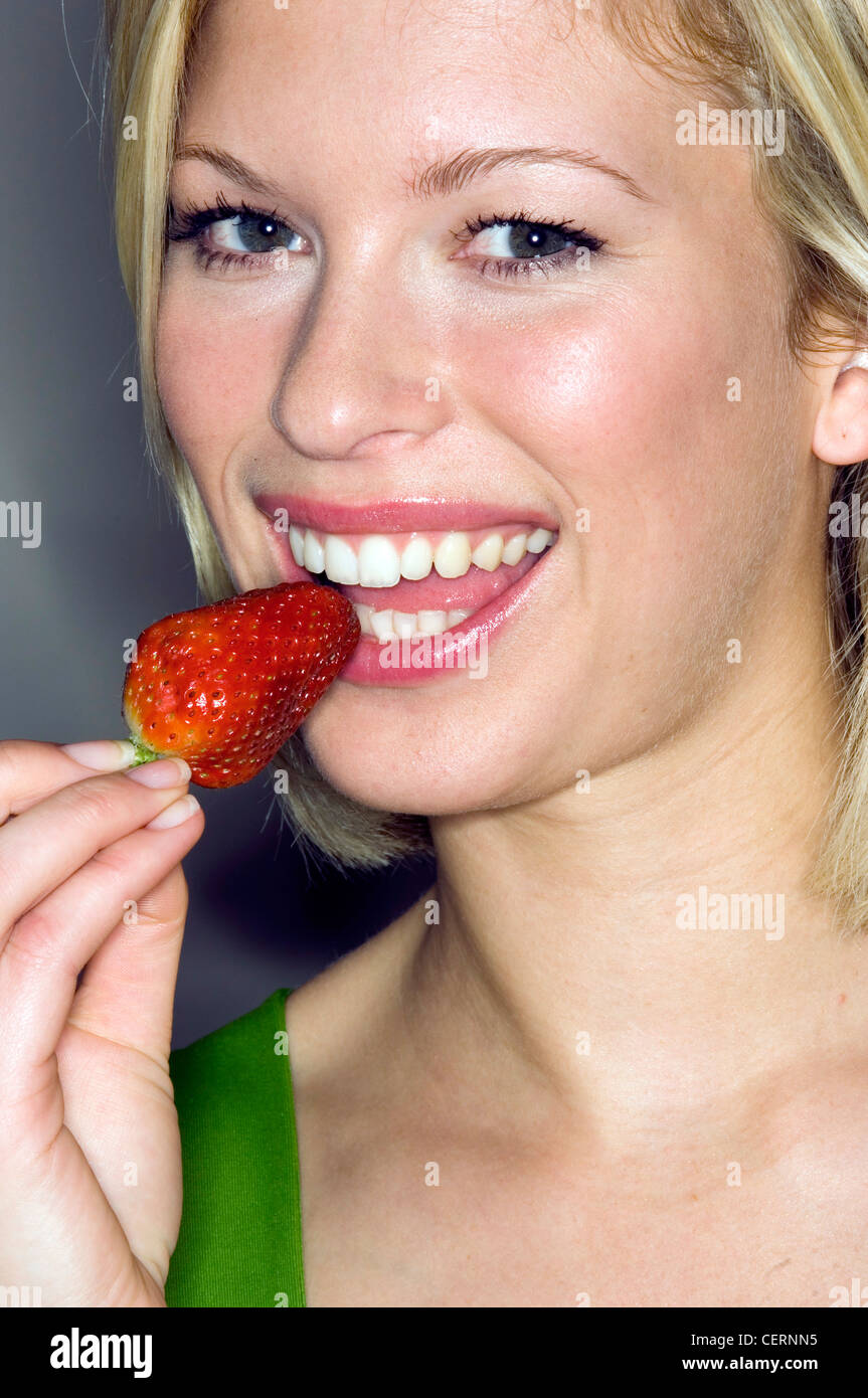 Female eating a strawberry Stock Photo - Alamy
