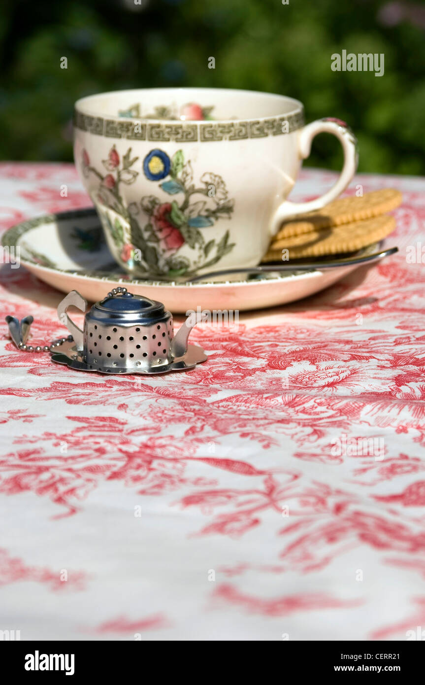 An English cream tea Cup of tea in a floral cup and saucer with ...