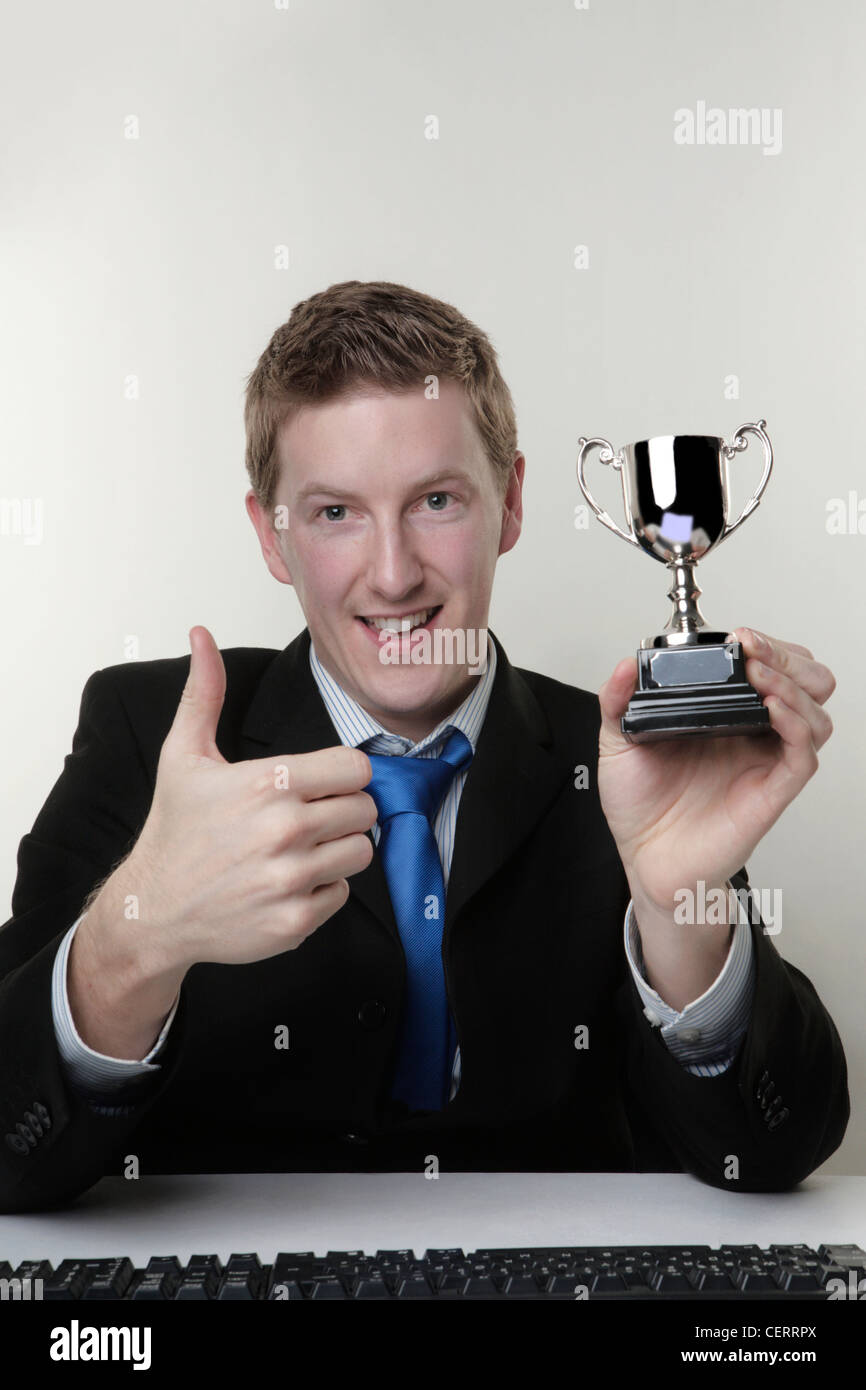 businessman holding up a cup medal to show that hes a winner Stock ...
