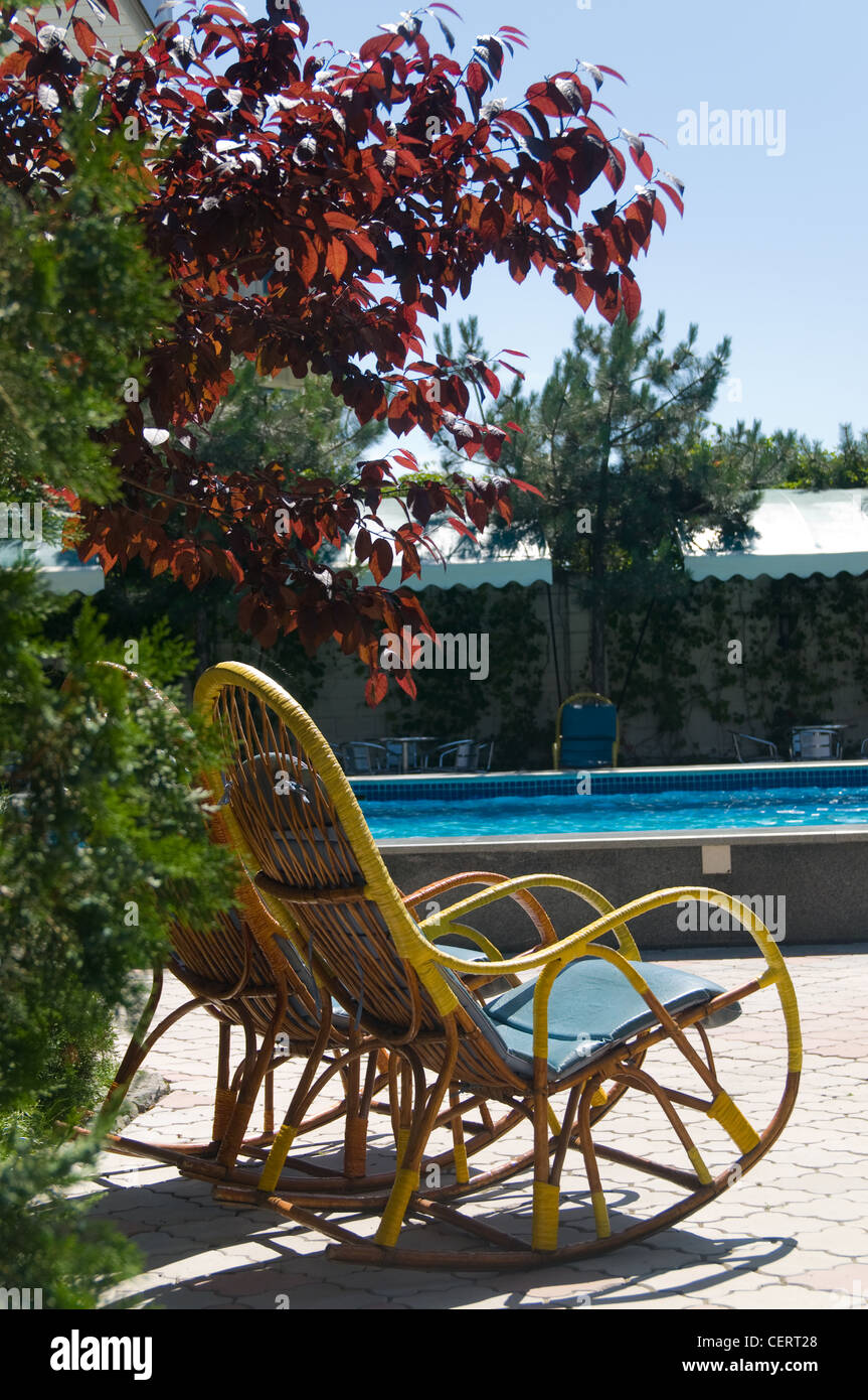 Rocking chair stands near the Swimming pool Stock Photo - Alamy