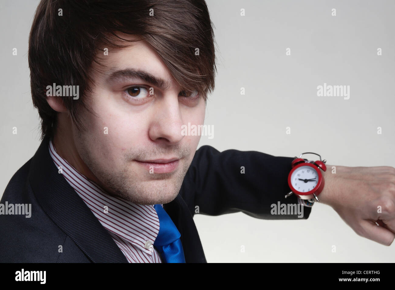 young business man looking at a large watch on his wrist Stock Photo ...