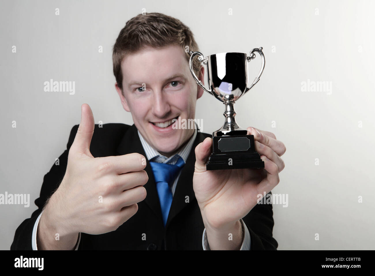 businessman holding up a cup medal to show that hes a winner Stock ...