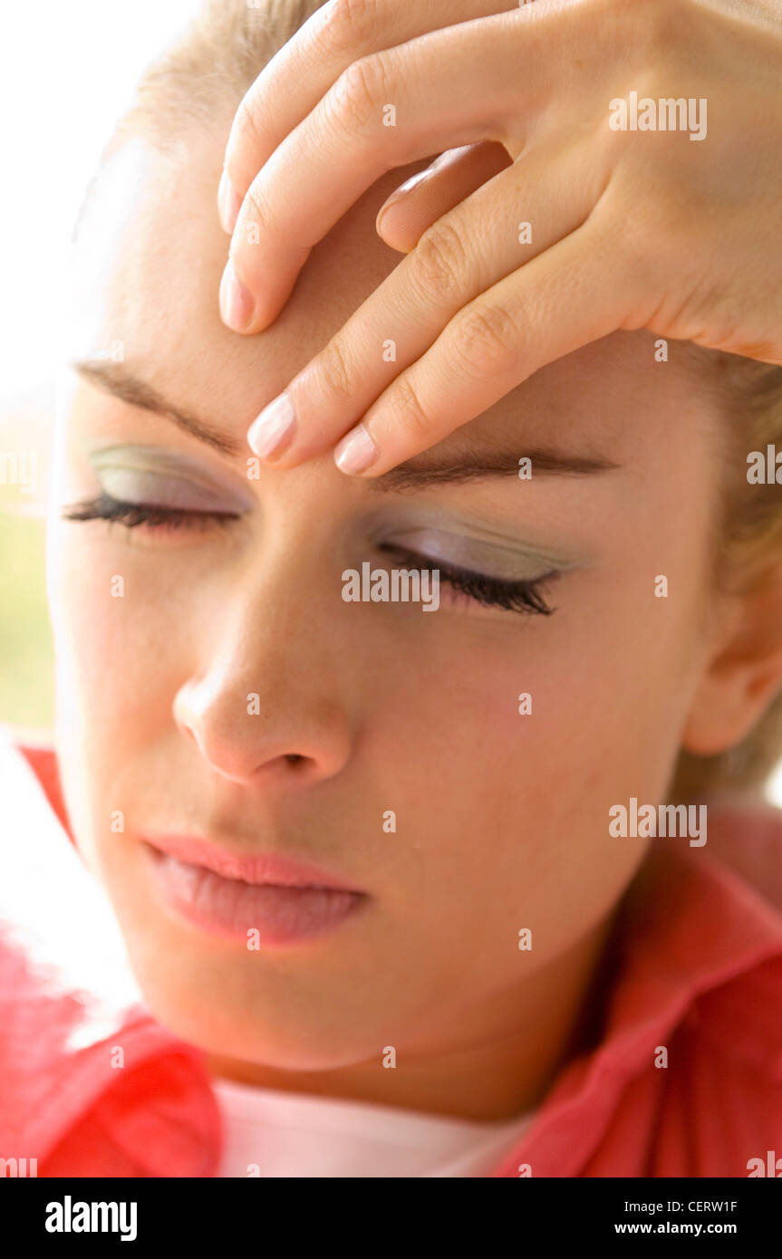 Female with hand on forehead Stock Photo - Alamy
