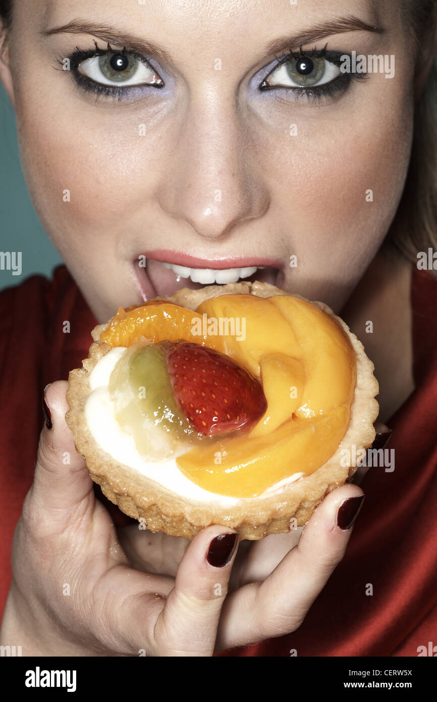 Female biting into an fruit flan Stock Photo - Alamy