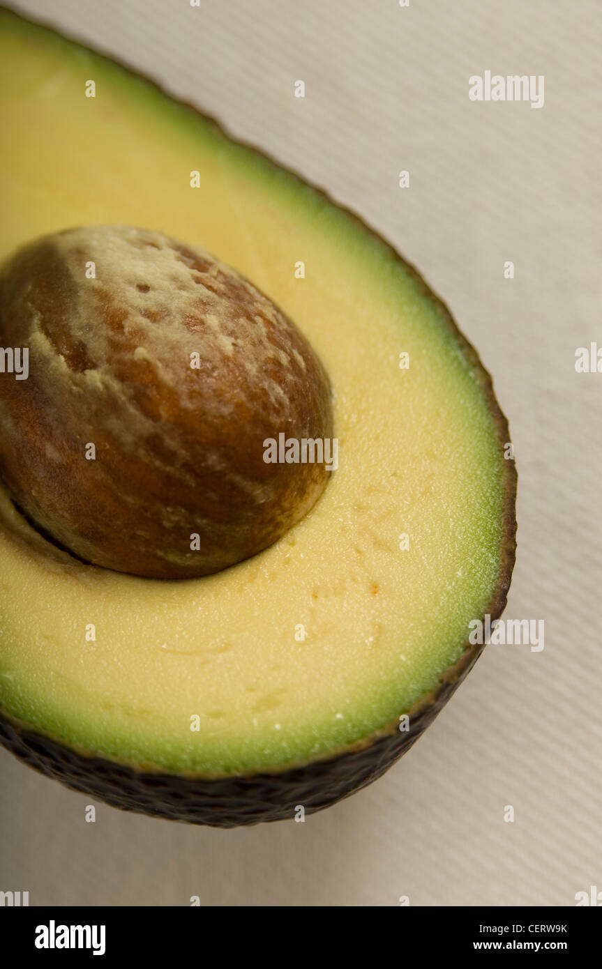 Half an avocado with the stone in it, on a white background Stock Photo ...