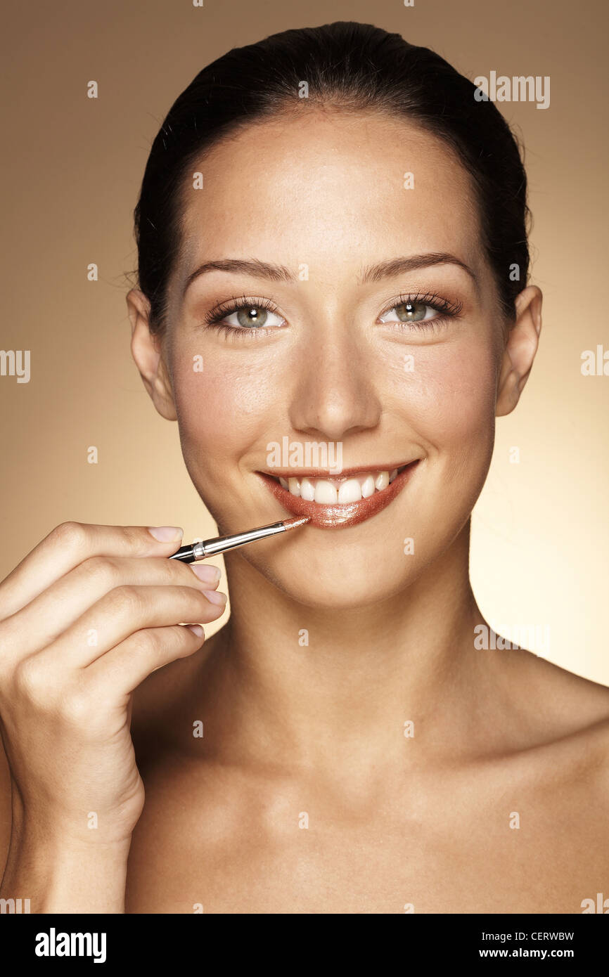 Female applying lipstick with a brush Stock Photo - Alamy