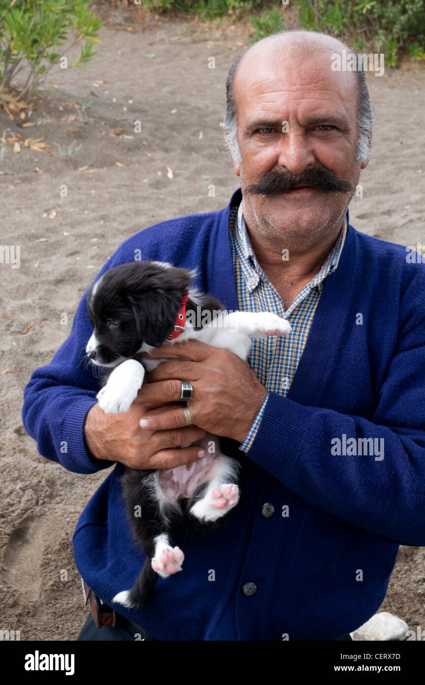 Portrait of a turkish man holding a puppy, Dalyan, Turkey Stock Photo ...