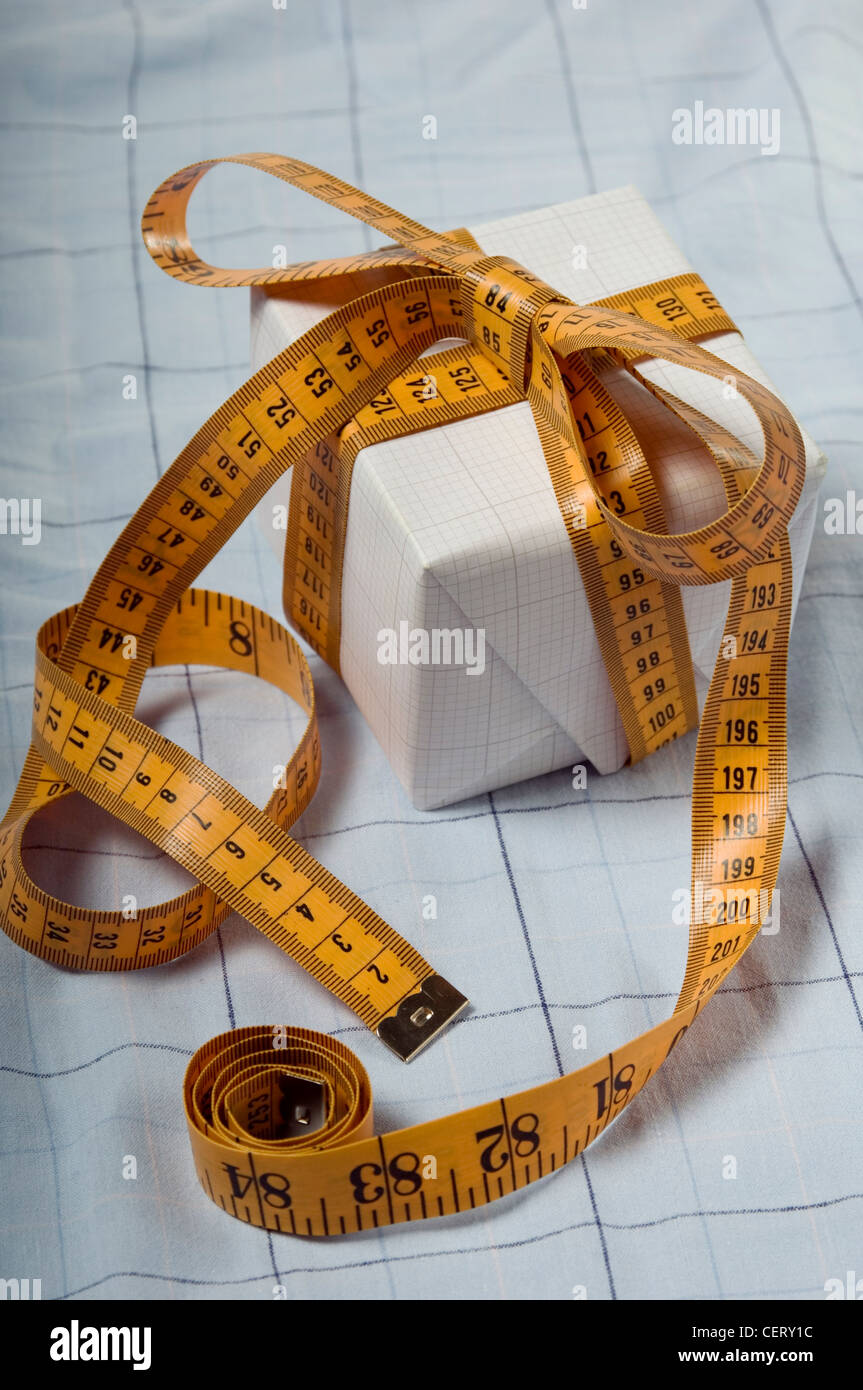 A still life of a present wrapped in graph paper and secured with a bow ...