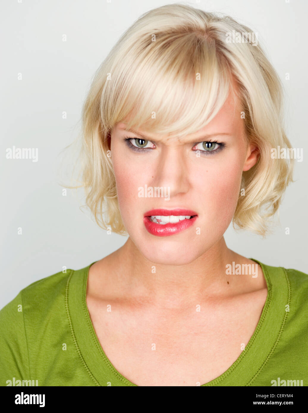 Female looking angry and biting lip Stock Photo - Alamy