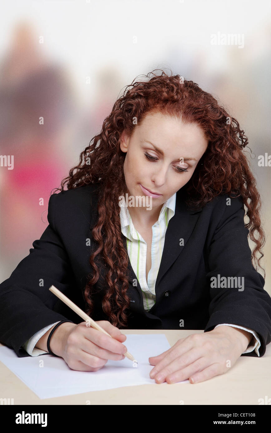 woman at her desk writing on paper Stock Photo - Alamy