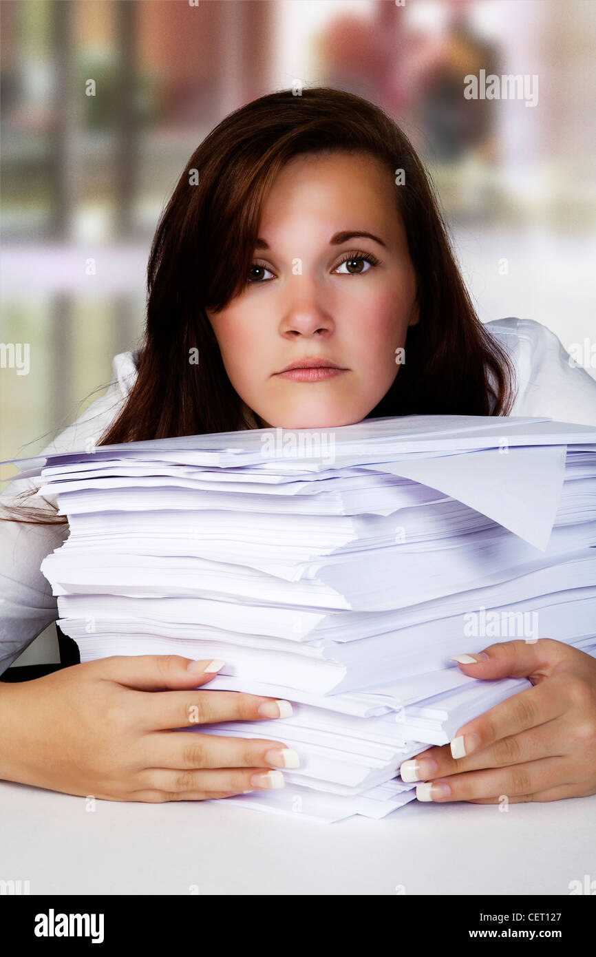 woman at desk looking and thinking about all the paper work she needs ...