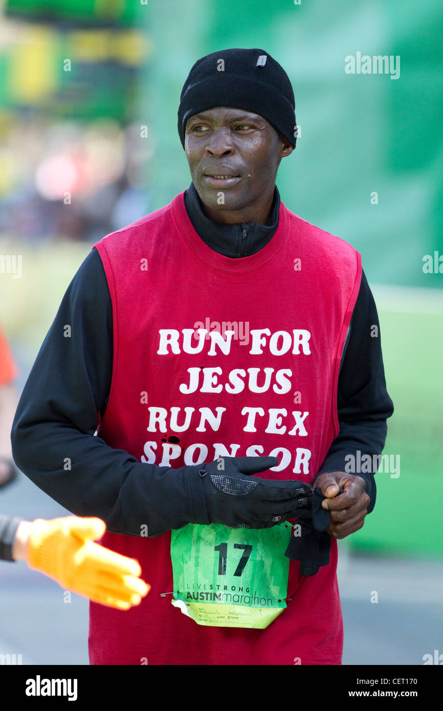 African-American male crosses finish line wearing "Run for Jesus" shirt ...