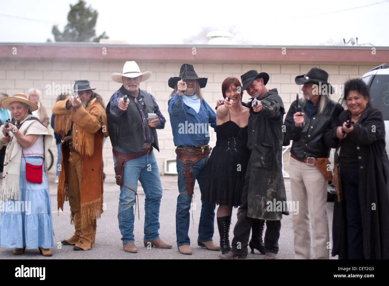 Cowboys shooting at the camera with their guns Stock Photo - Alamy