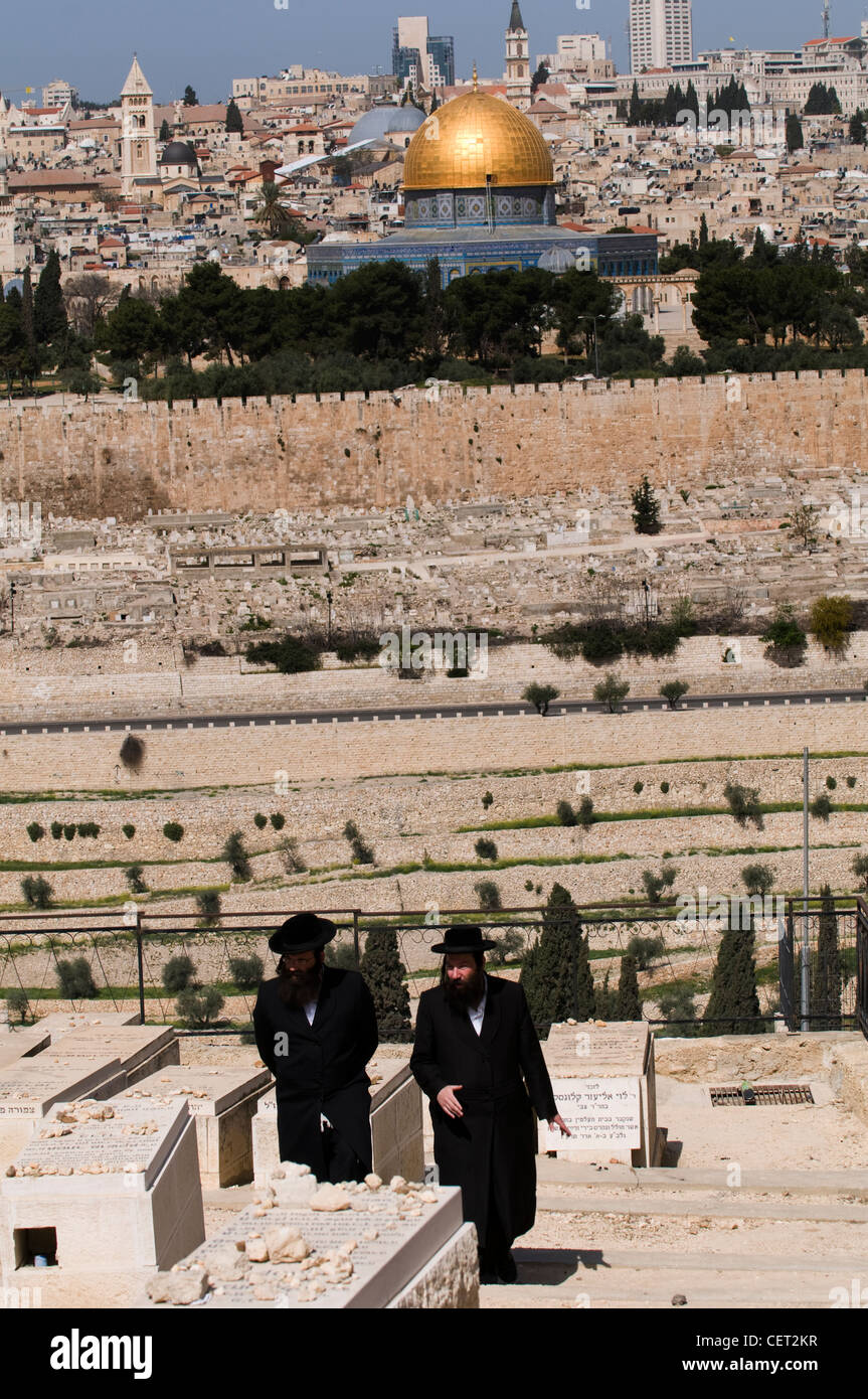 Orthodox Jewish men walking through the Jewish cemetery on the Mount of ...