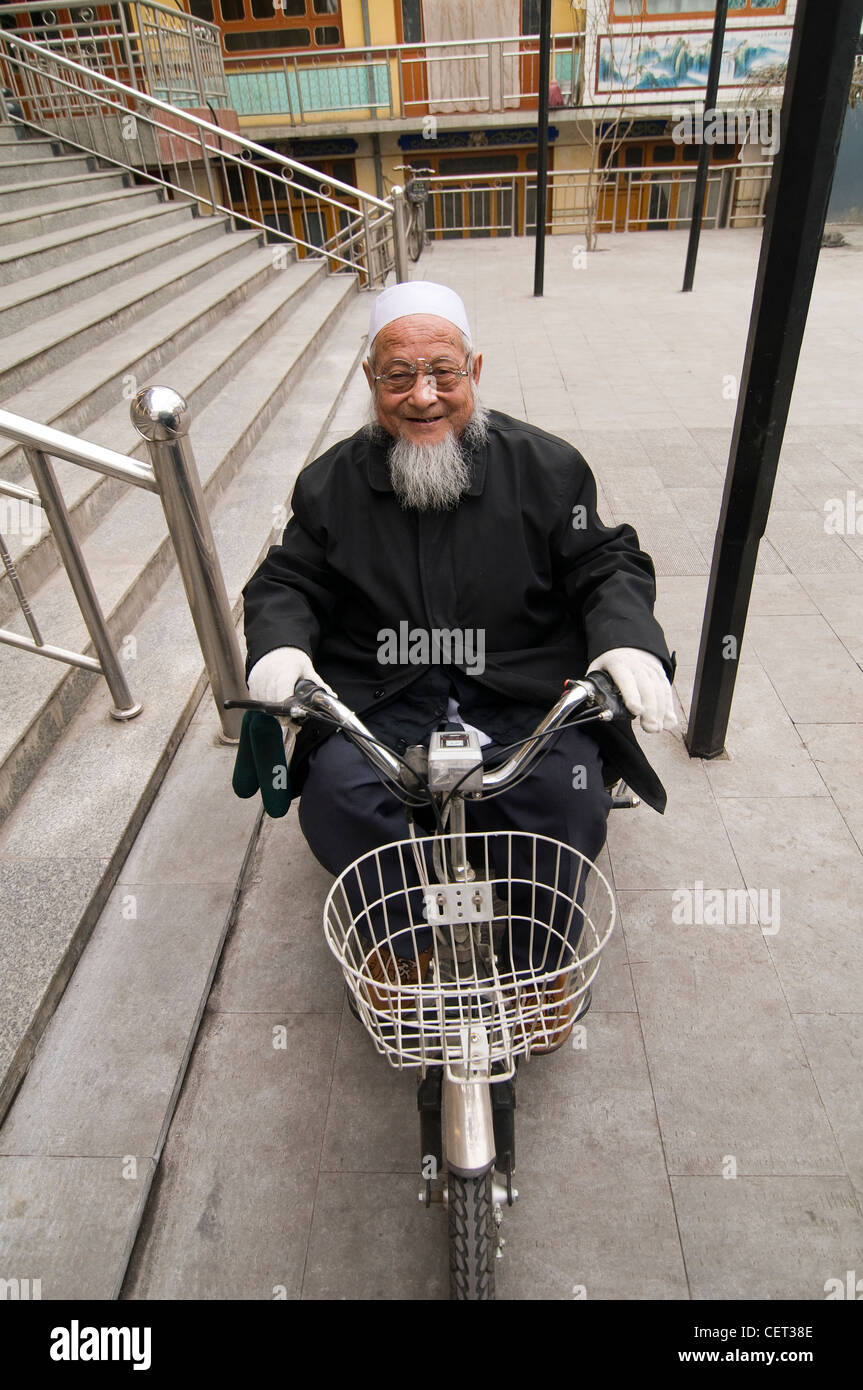 A smiling Muslim man riding his small bike Stock Photo - Alamy