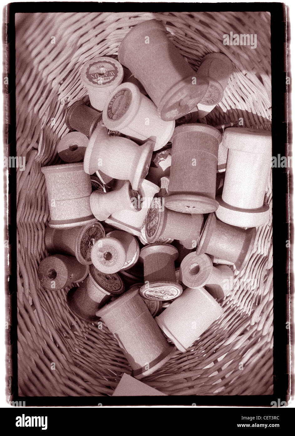 Thread spools empty in basket. Still life vertical photo sepia toned ...