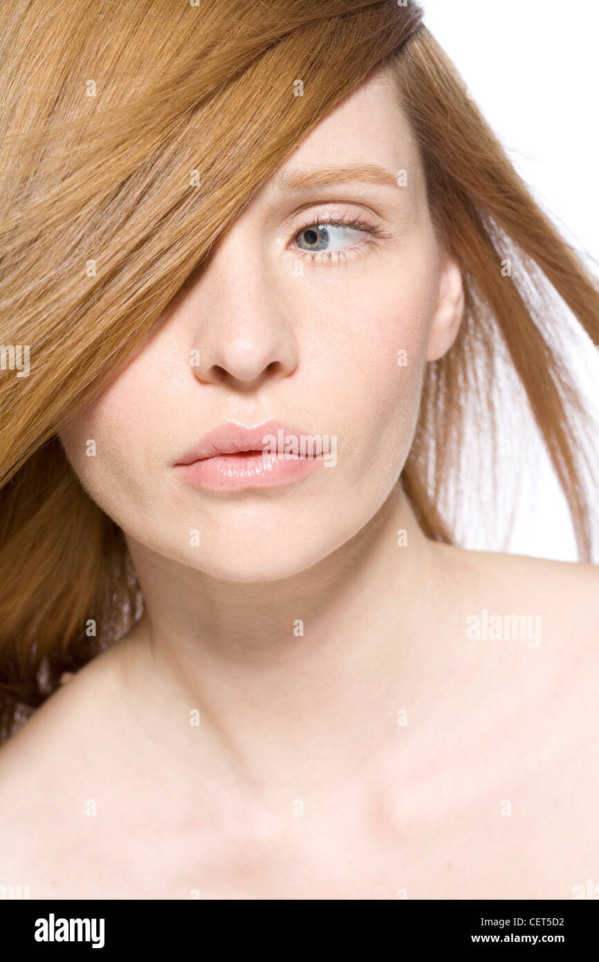 Female with long straight fair hair over face, unsmiling, looking aside ...