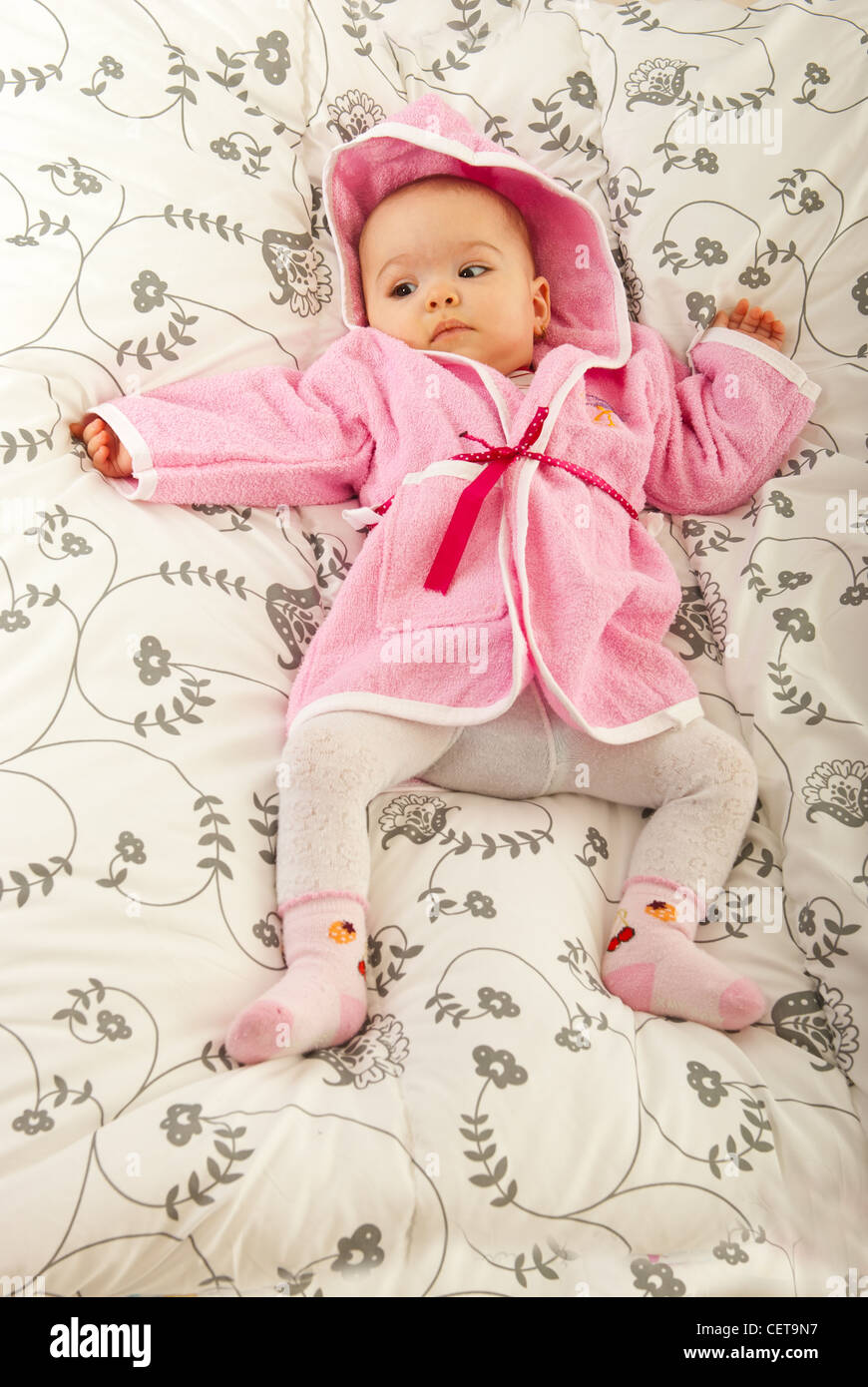 Rear view of baby girl lying in bed and looking away Stock Photo - Alamy