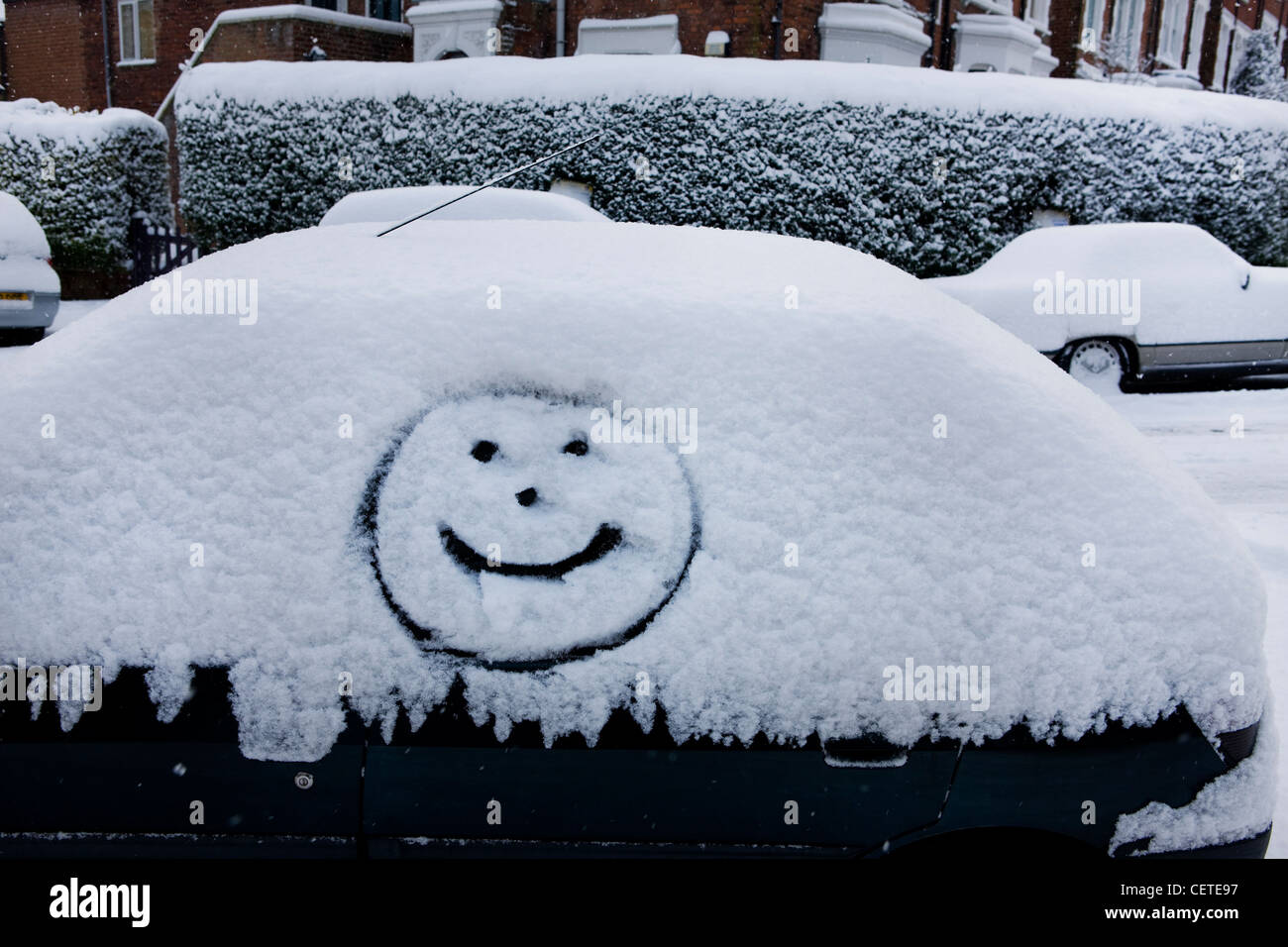 London streets and car with smiley face covered in snow after a ...