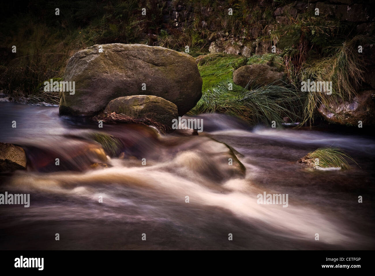Fast running water cascading over rocks in a stream in the Lake ...