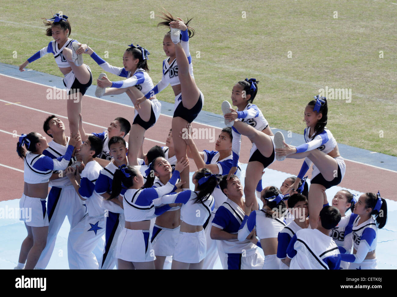 High school girls and boys play cheerlead in athletic field Stock Photo ...