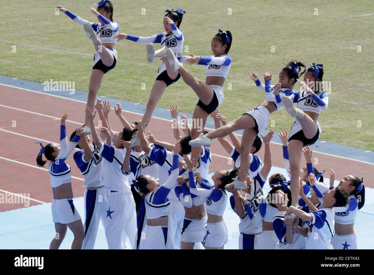 High school girls and boys play cheerlead in athletic field Stock Photo ...