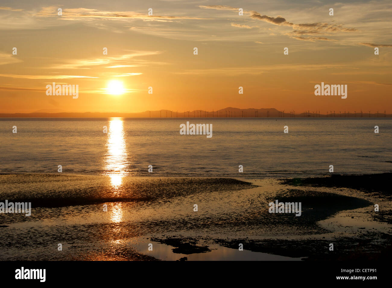 Golden setting Sun at low tide with sandy beach Stock Photo - Alamy